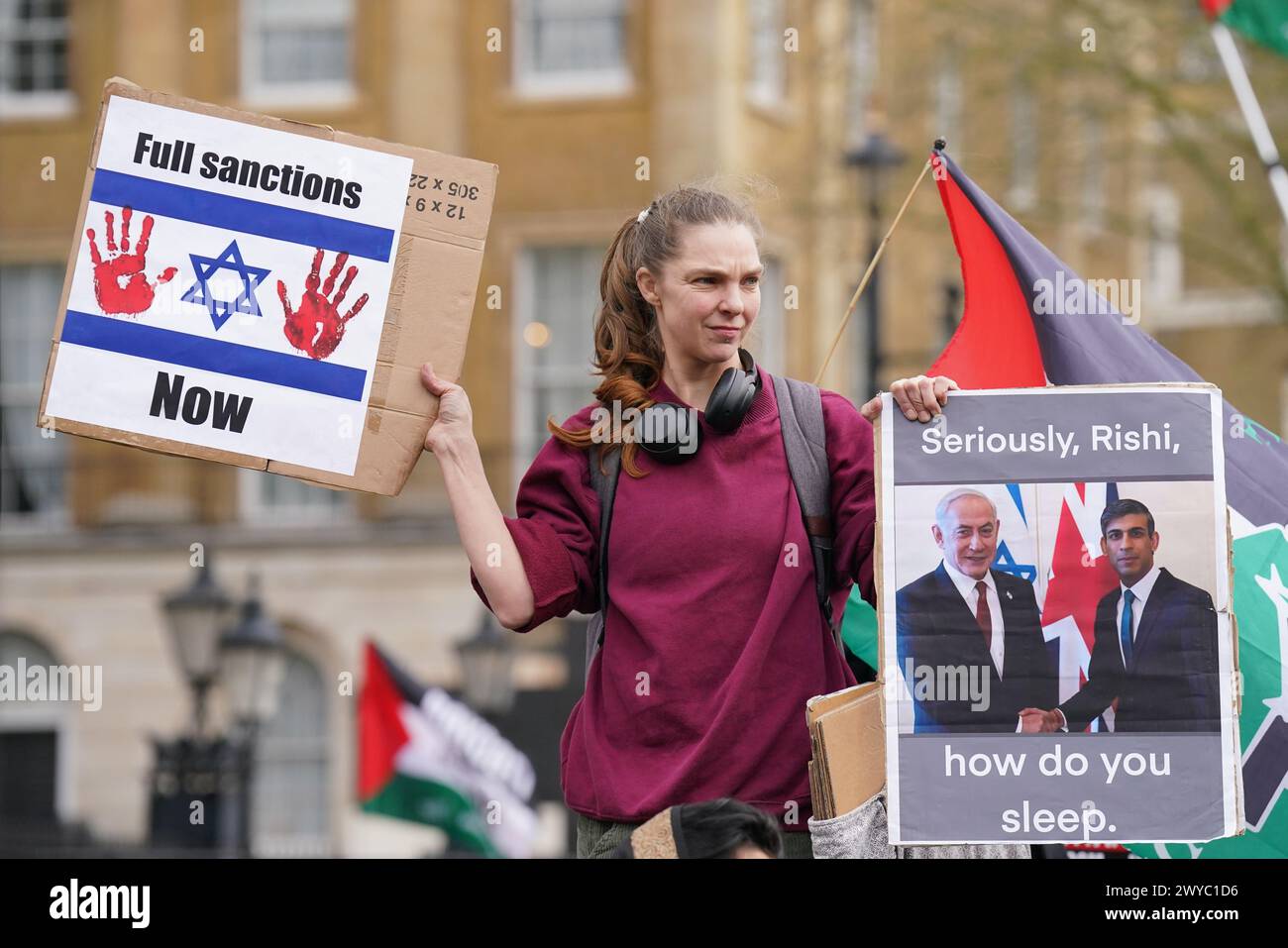 A person holds up posters as demonstrators march through London, during ...