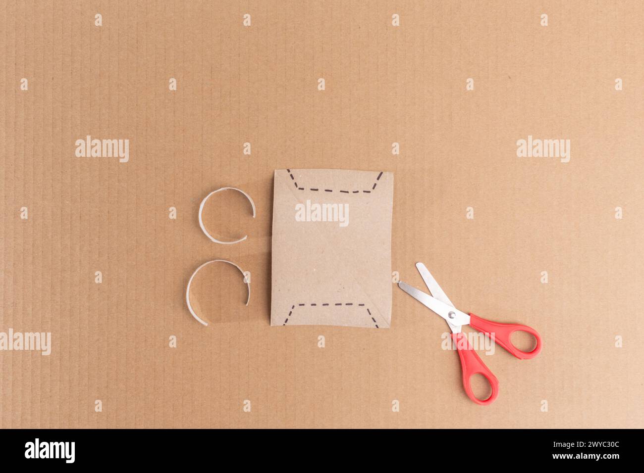 Scissors are positioned atop a cardboard-cut paper Stock Photo - Alamy