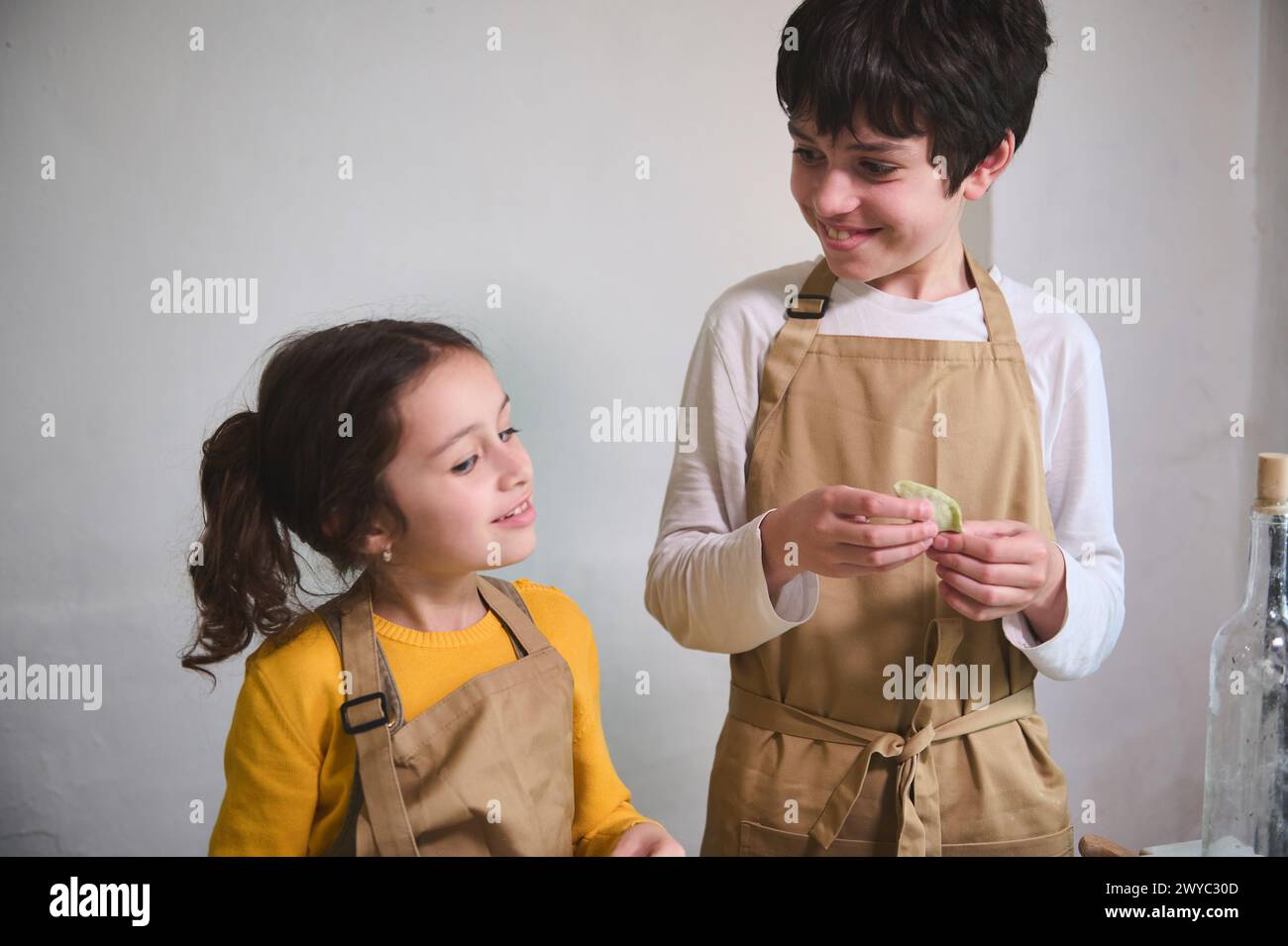 Authentic portrait of two adorable smiling kids making homemade ...