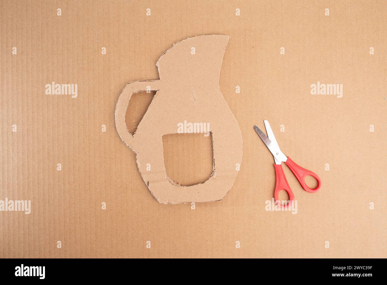 a paper cut out of a pitcher next to a pair of scissors, cut out of ...