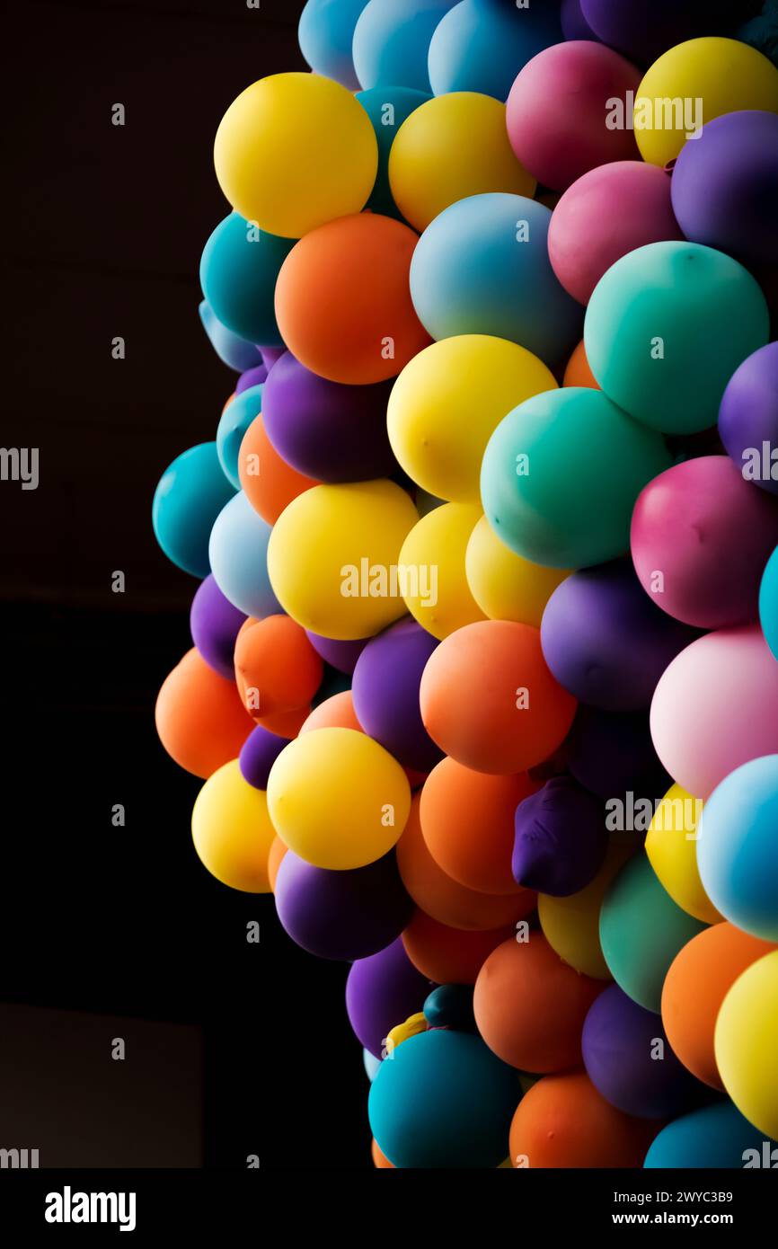 dozens of colored flying balloons joined together Stock Photo - Alamy