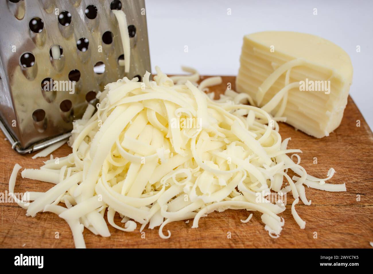 Romanian pressed cheese called cascaval, grated on a chopping board ...
