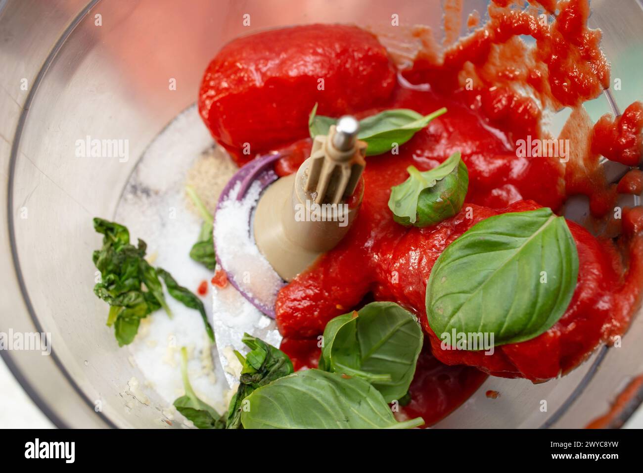 Making home made ketchup with peeled tomatoes, basil leaves, garlic ...