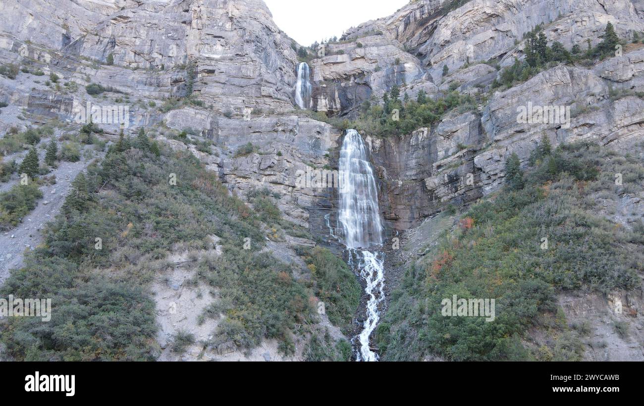 Waterfall cascading in rocky terrain with evergreen trees Stock Photo ...