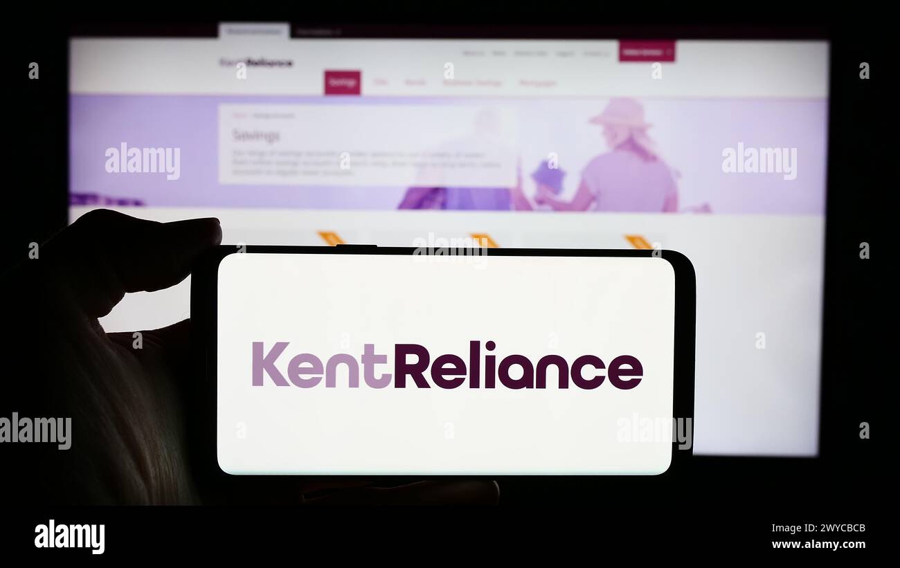Person holding cellphone with logo of British financial services company Kent Reliance in front ...
