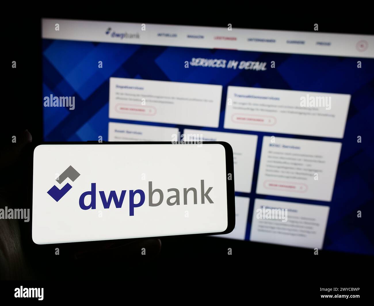 Person holding mobile phone with logo of company Deutsche ...