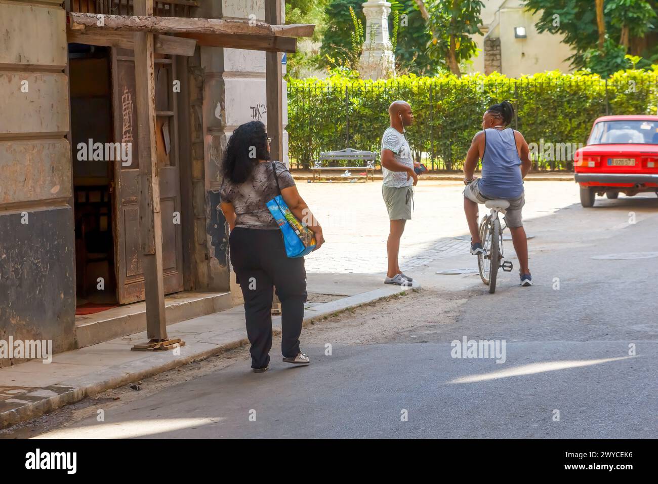 Cuban people's lifestyle by a building supported with wooden beams in ...