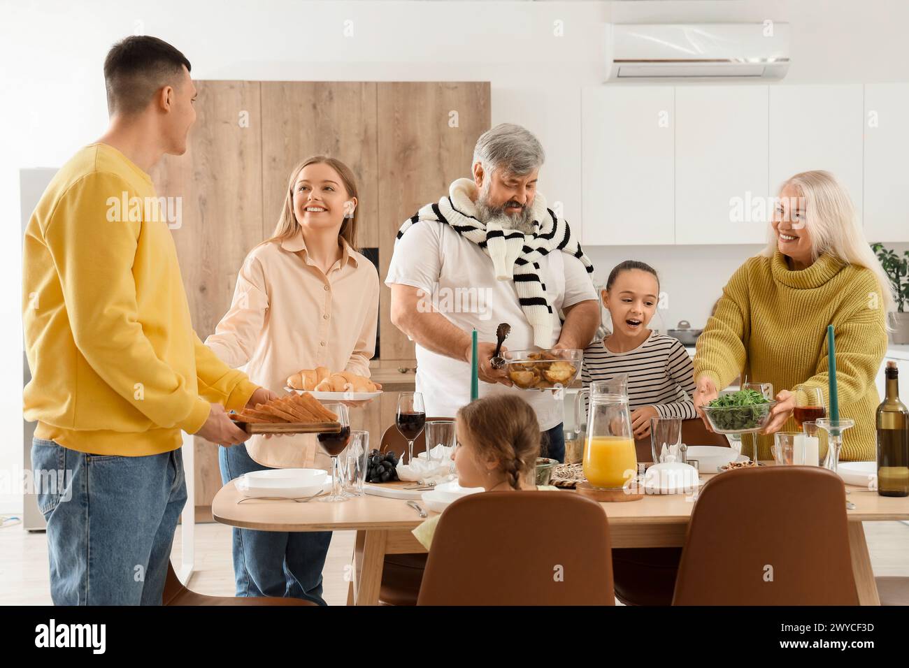 Big family setting dining table in kitchen Stock Photo - Alamy