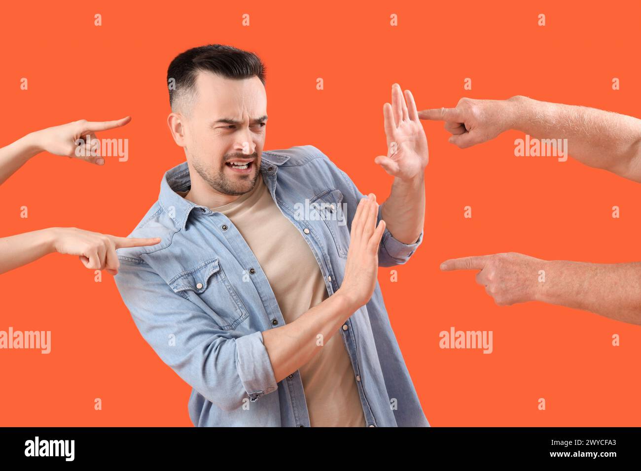 People pointing at young man on orange background. Accusation concept ...