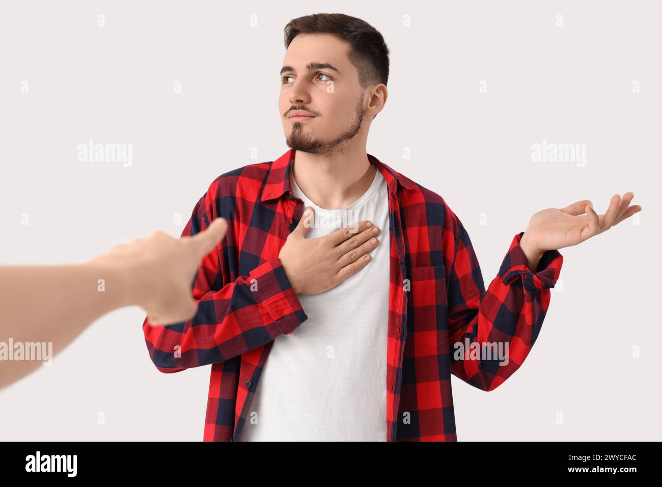 Woman pointing at young man on white background. Accusation concept ...