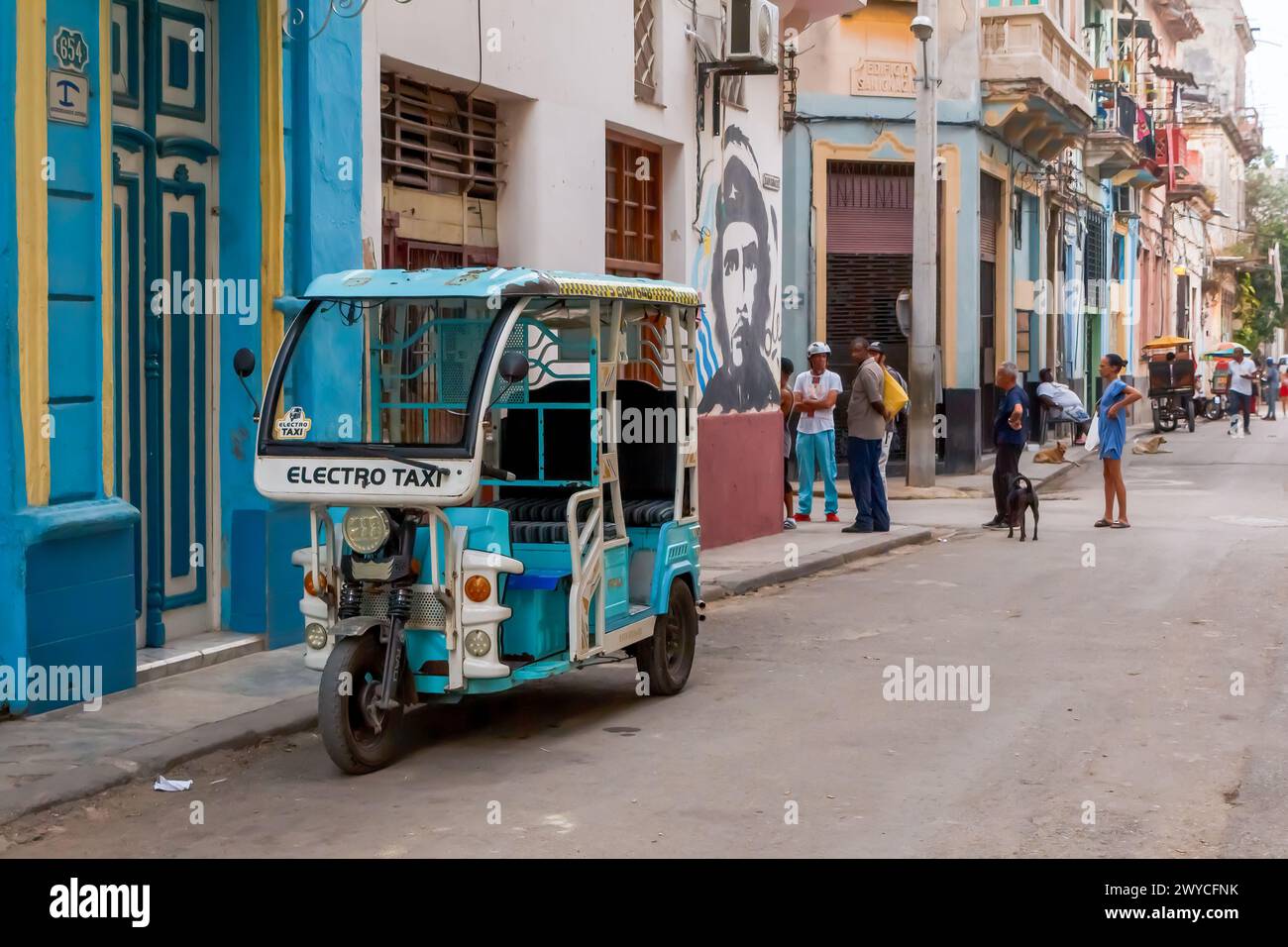 Electric tricycle reading Electro Taxi, Cuban people on a city street ...