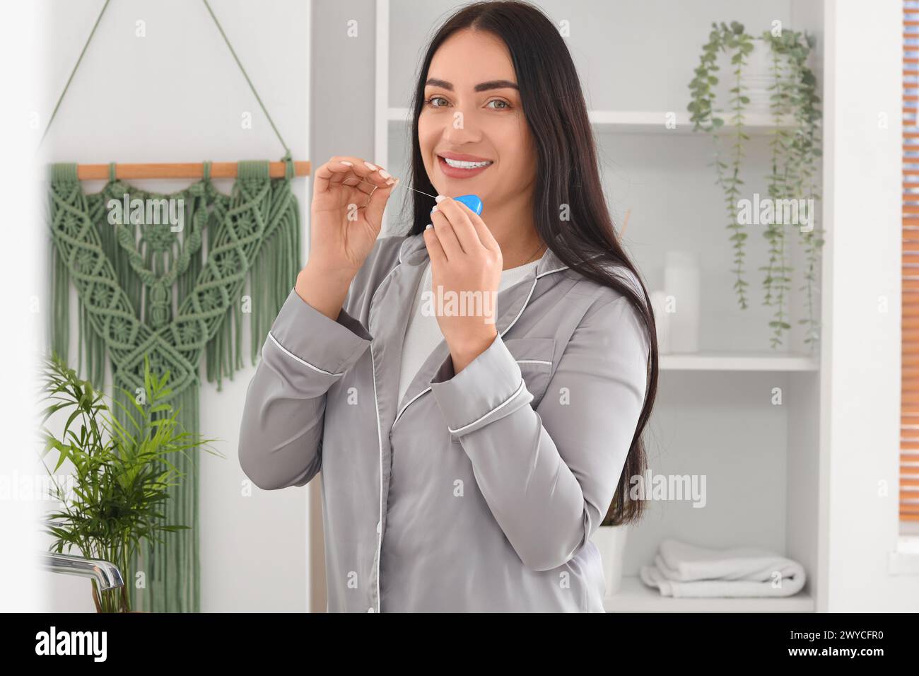 Beautiful young happy woman with dental floss in bathroom at home Stock ...