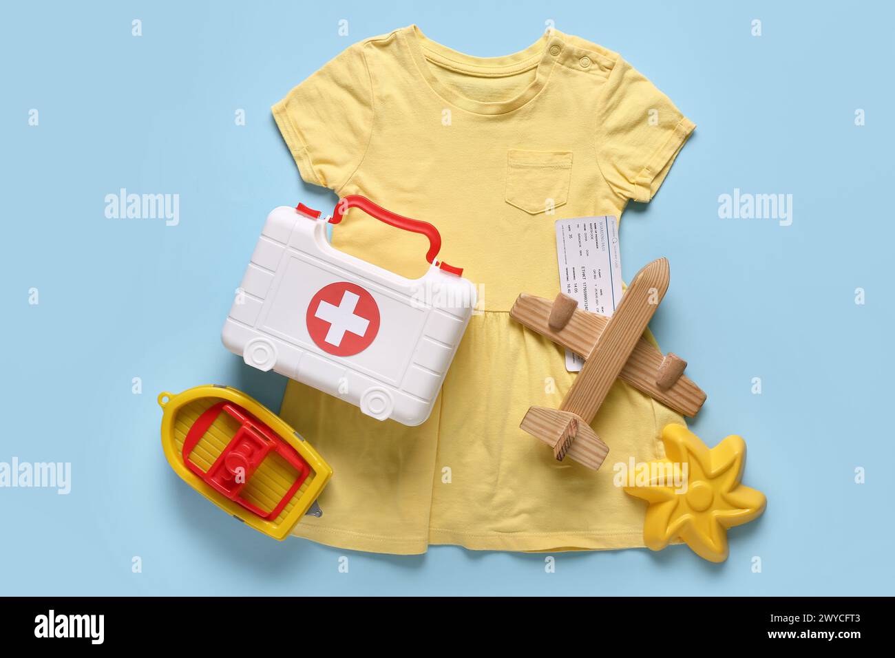 Toy first aid kit with dress and airplane on blue background. Top view ...
