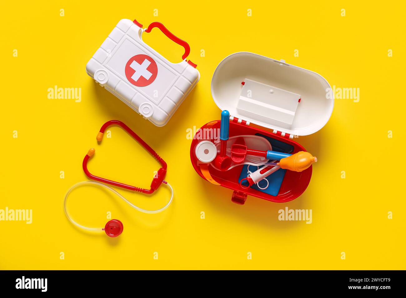 Toy first aid kits with stethoscope on yellow background. Top view ...