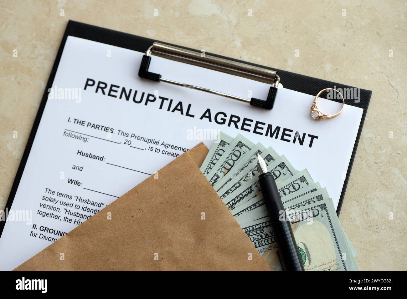 Prenuptial agreement and wedding ring on table. Premarital paperwork ...