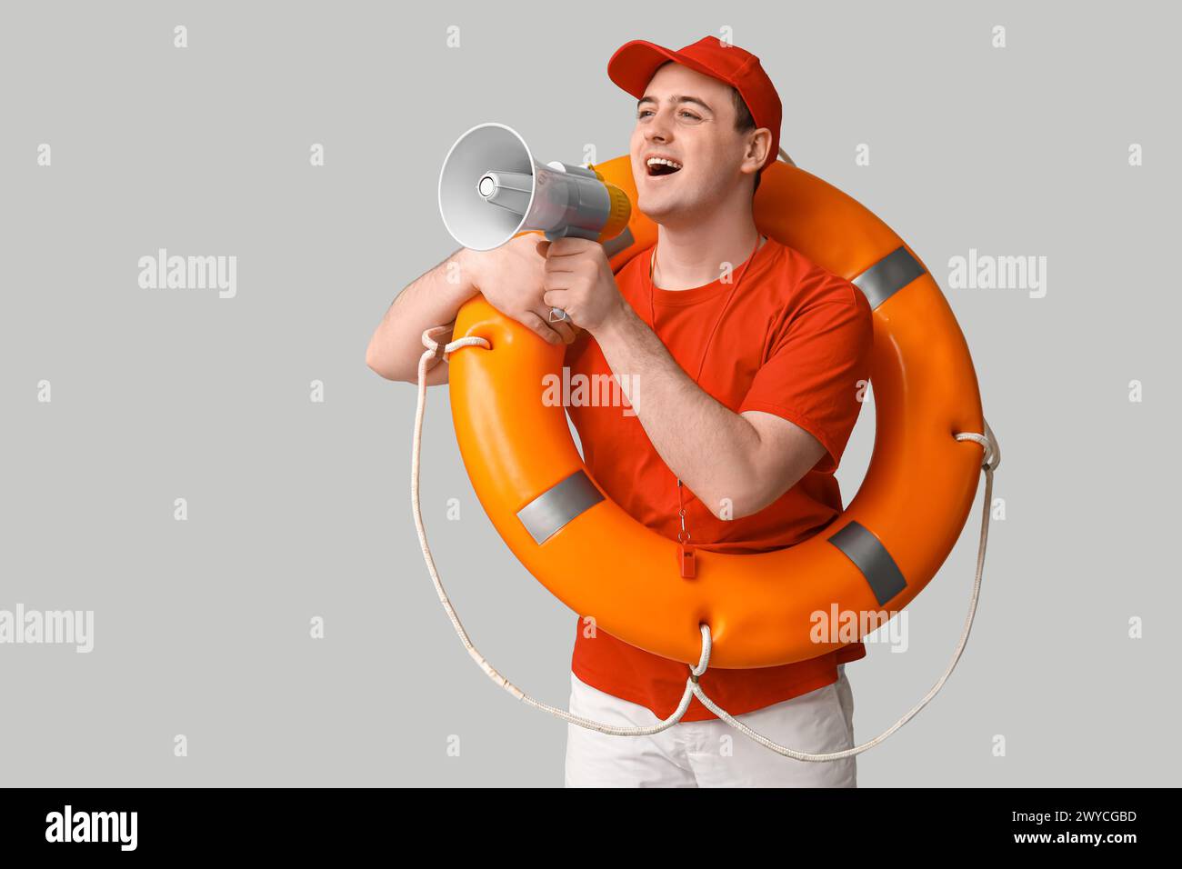 Male lifeguard with ring buoy and megaphone on grey background Stock ...