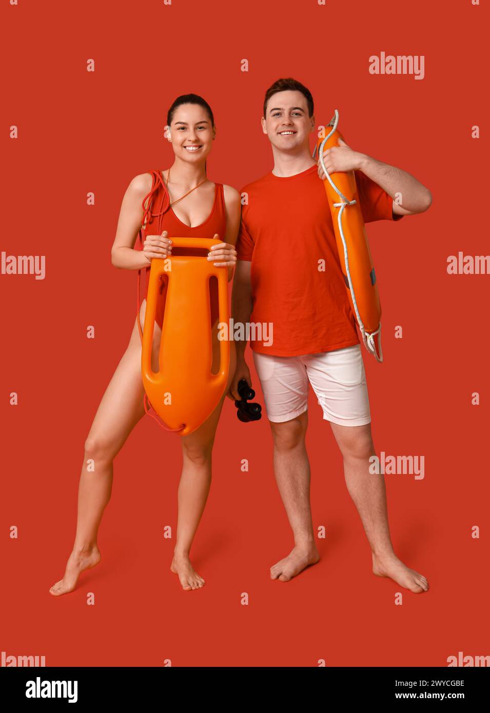 Lifeguards with ring buoy, rescue tube and binoculars on red background ...