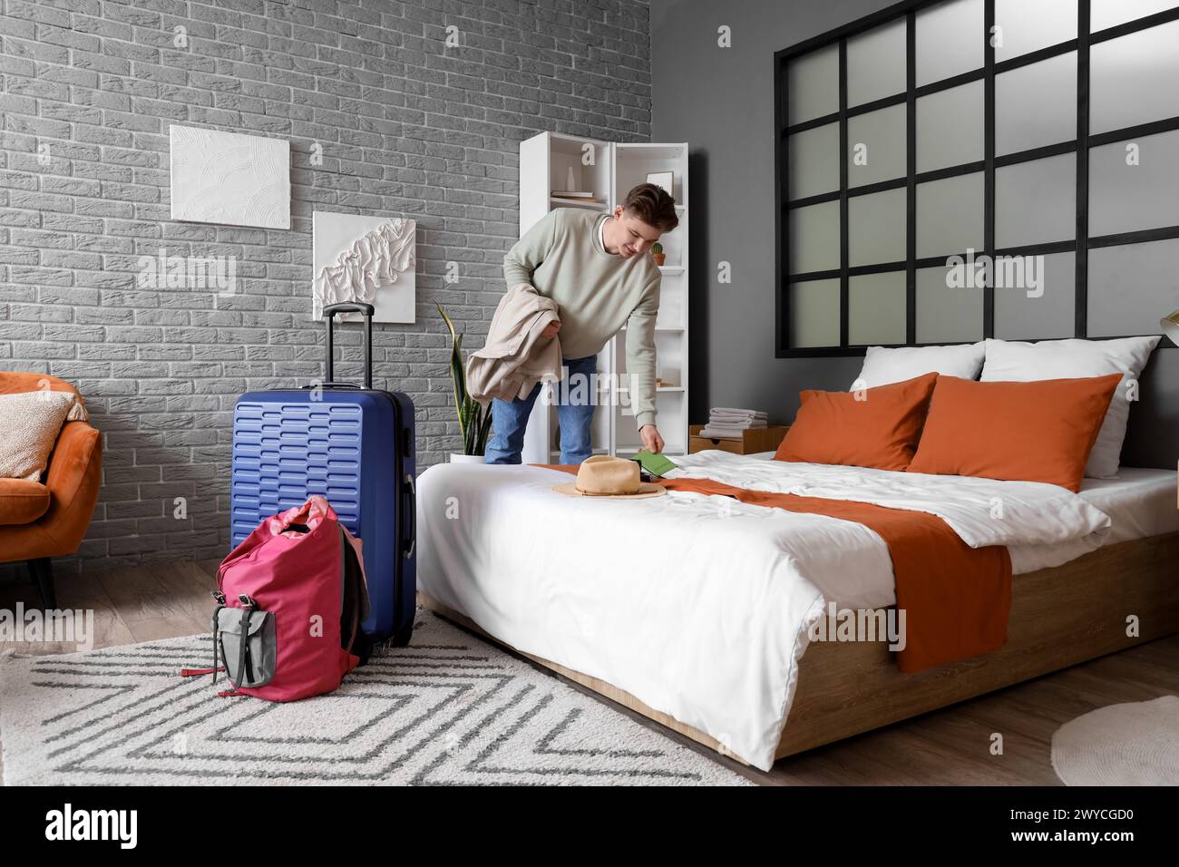 Male tourist with passport in hotel room Stock Photo - Alamy