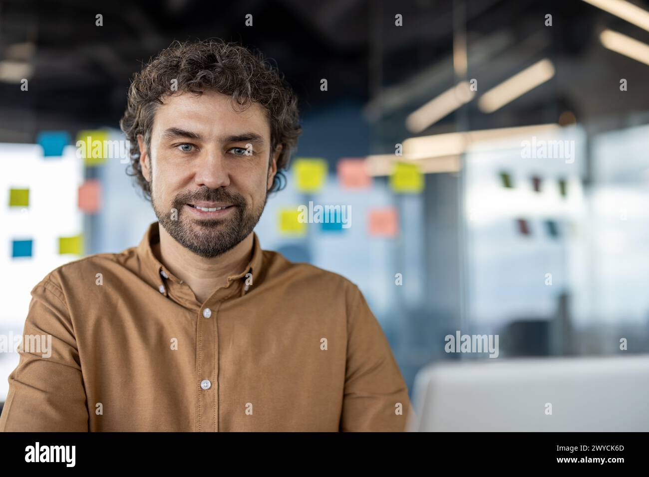 Portrait of a confident professional man with a warm smile, standing in ...