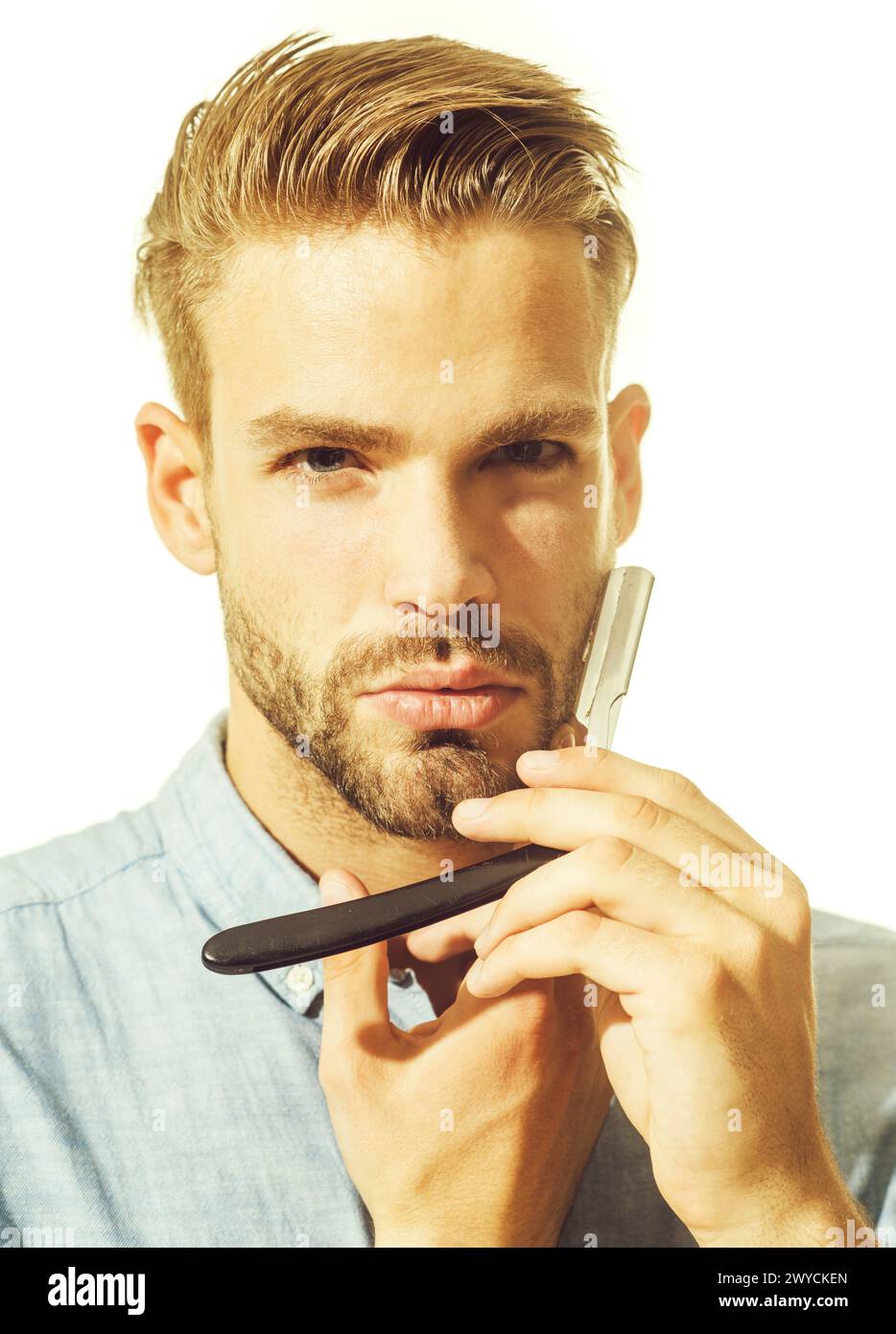 Brutal bearded man with straight razor. Handsome hairdresser in stylish ...