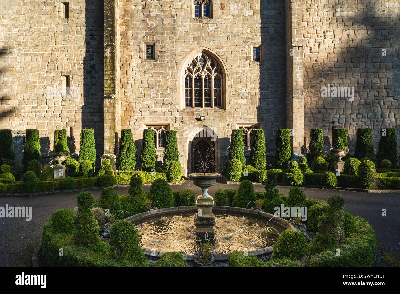 The formal garden and front doorway of a historic castle with ornate ...