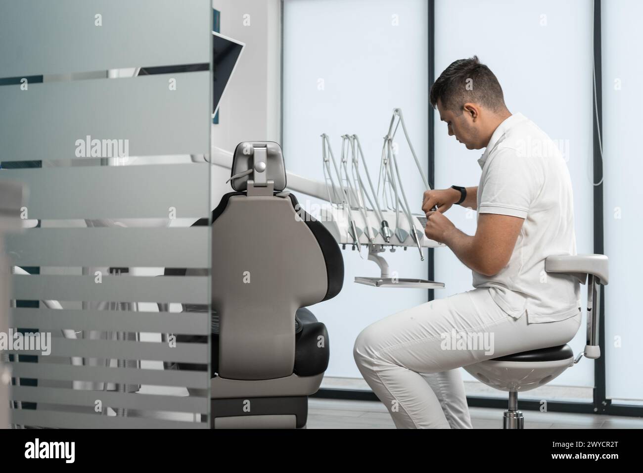 A highly qualified male dentist in his dental office, ready to take on ...
