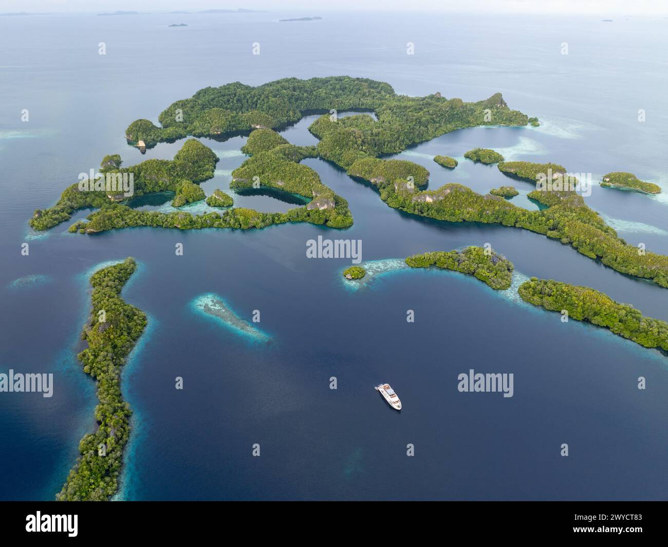 The scenic limestone islands of Pef, fringed by reef, rise from Raja ...