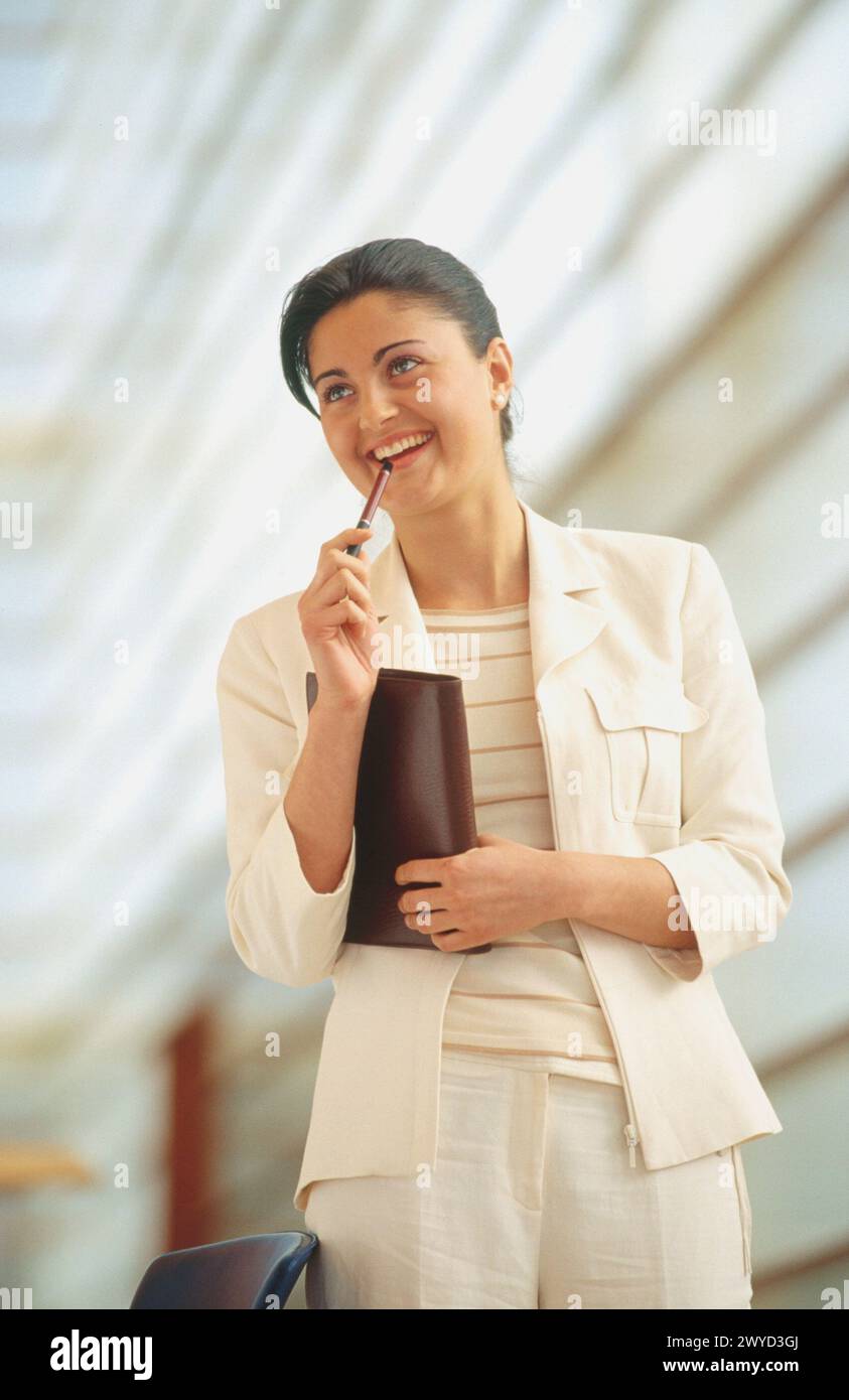 Young woman biting pen hi-res stock photography and images - Alamy
