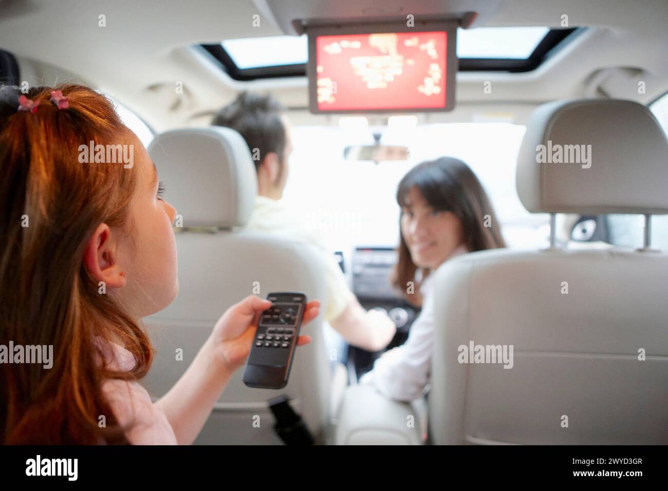 Family travelling, girl watching DVD in car Stock Photo - Alamy