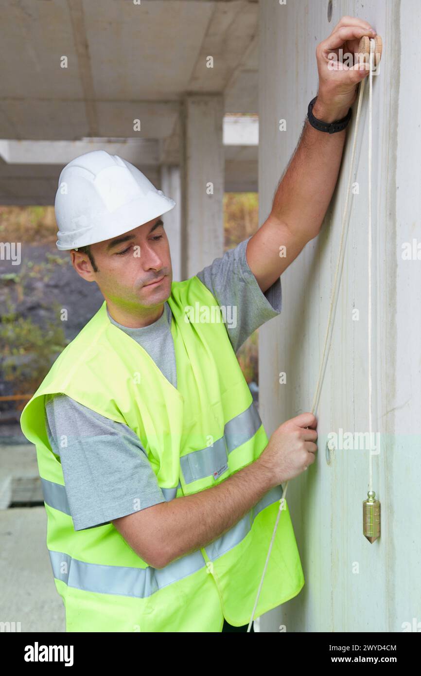 Worker with protective equipment, PPE, Checking and aligning vertical ...