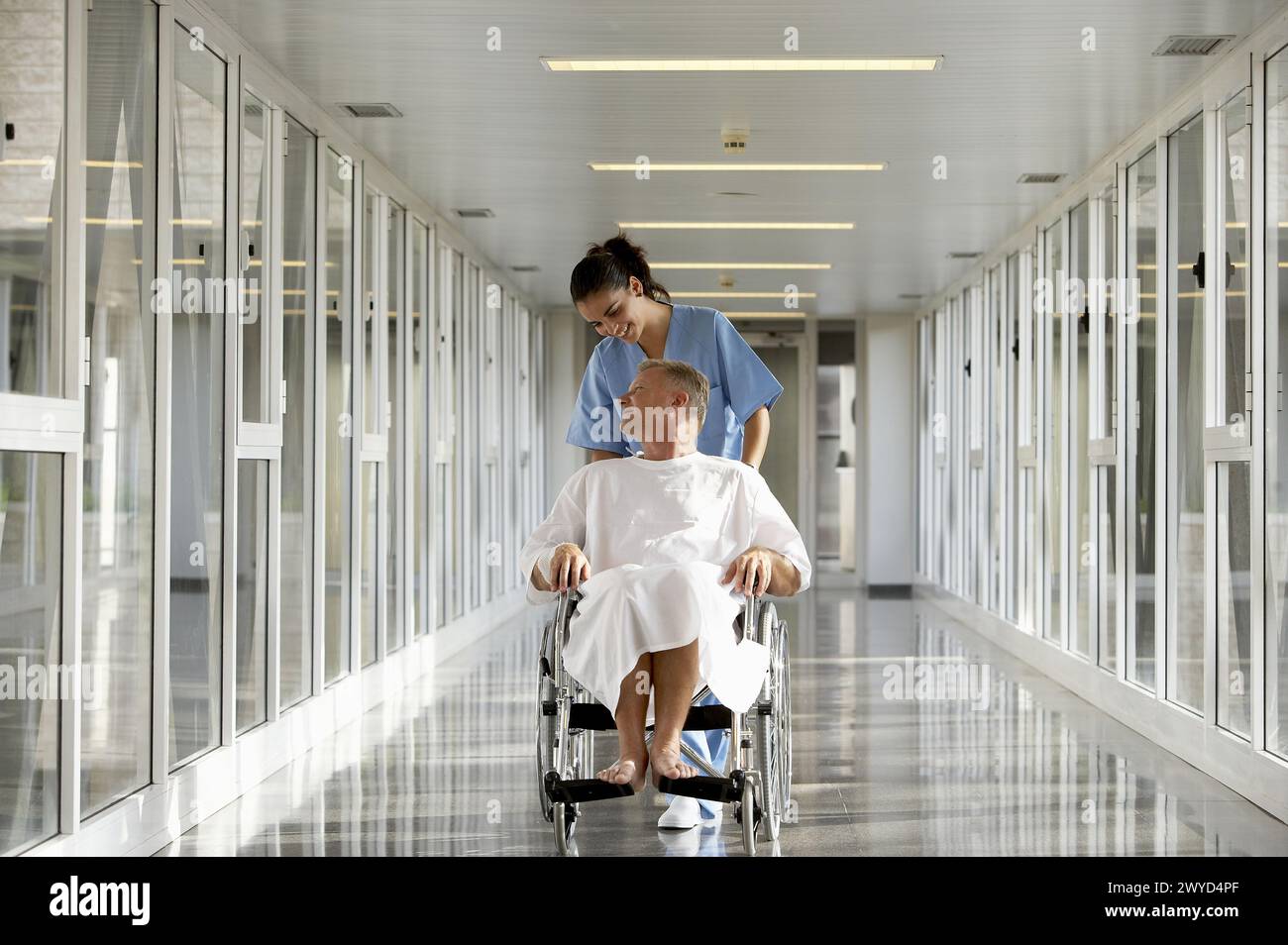 Nurse pushing patient in wheelchair Stock Photo - Alamy