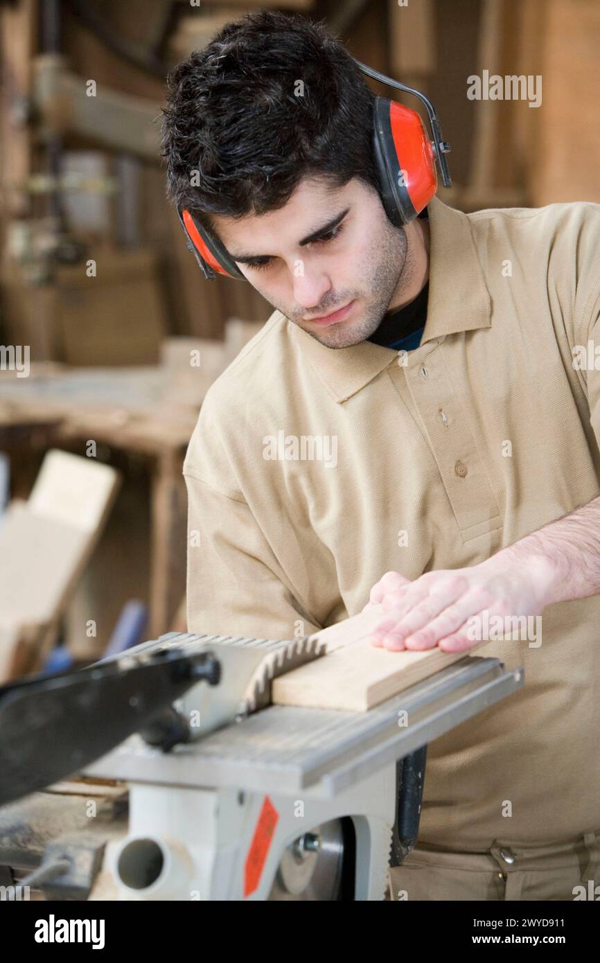 Carpenter cutting wood with electrical saw. Wood carpentry Stock Photo ...