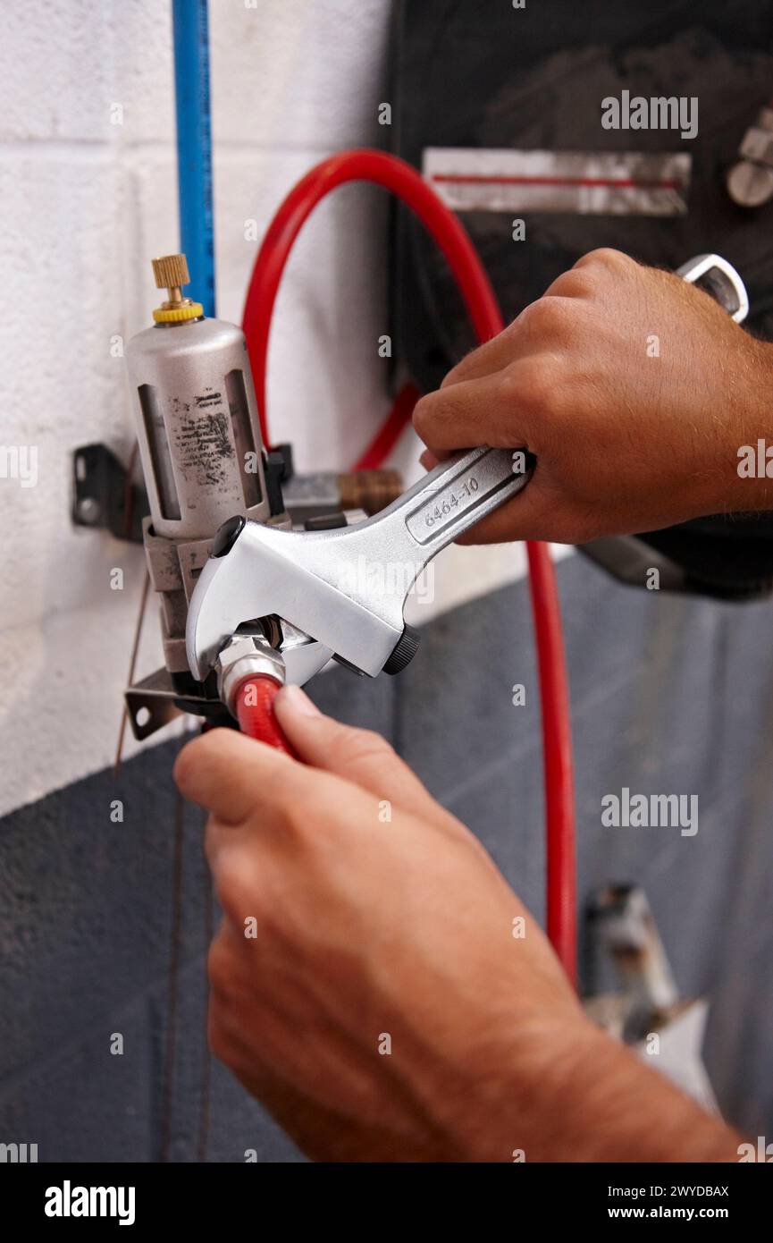 Worker using adjustable spanner in car repair shop Stock Photo - Alamy