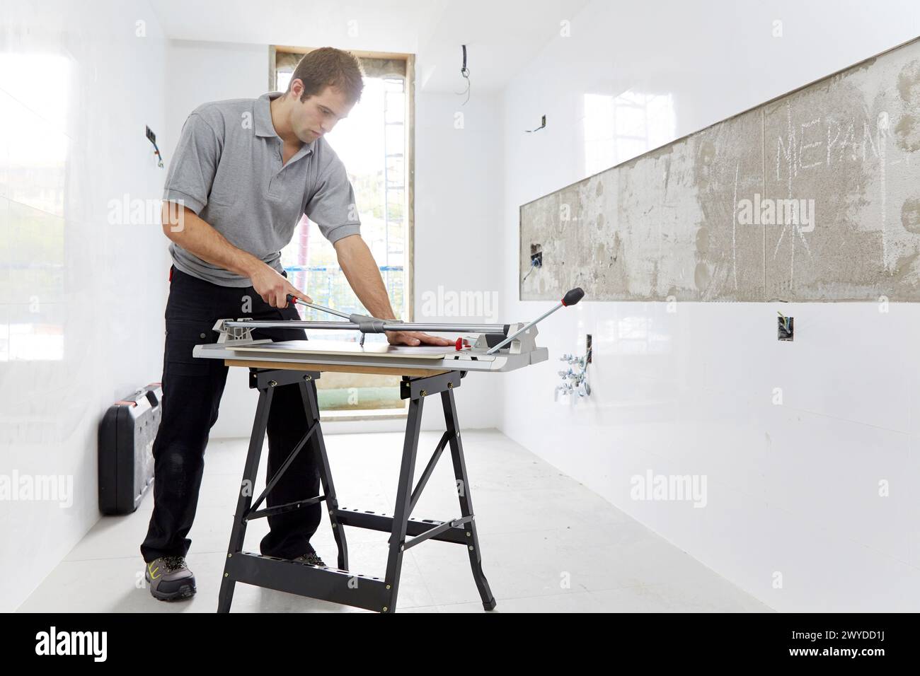 Bricklayer cutting tile. Manual tile cutter. Construction Industry ...