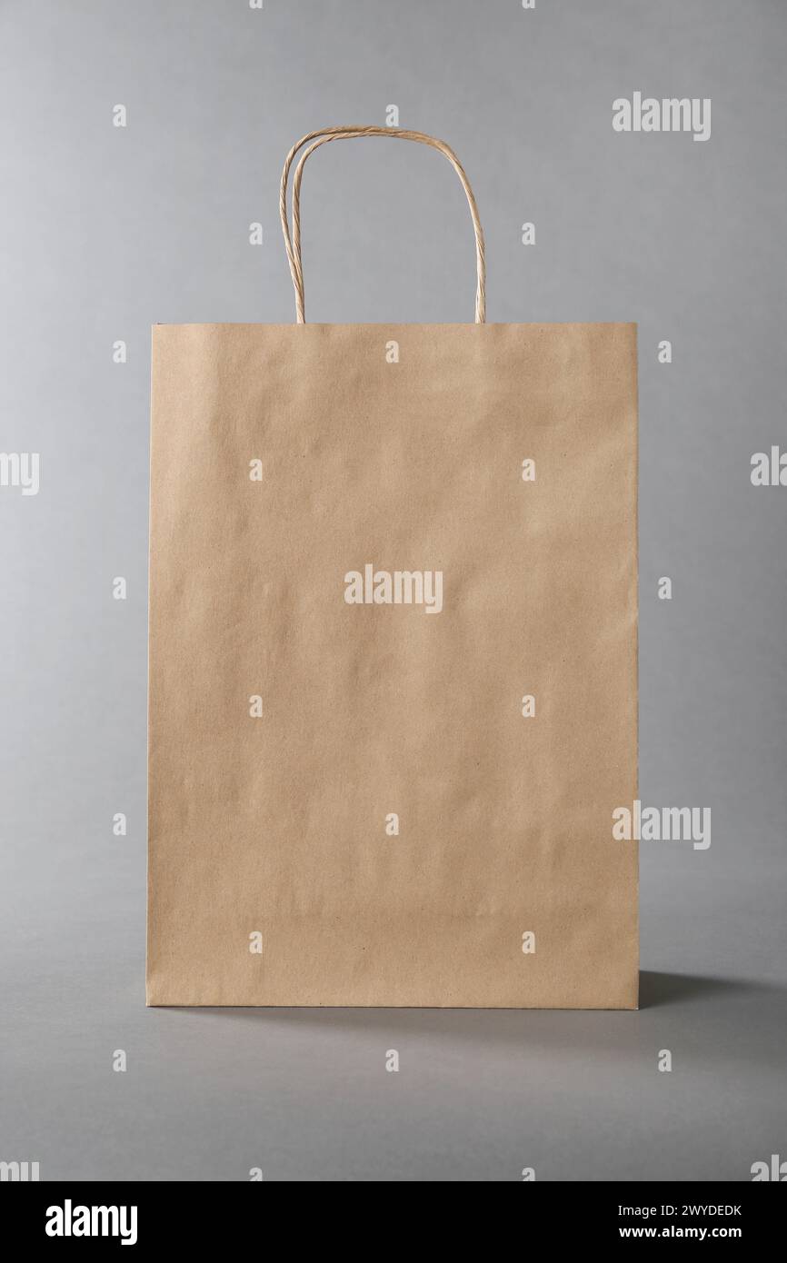One kraft paper bag on grey background. Mockup for design Stock Photo ...