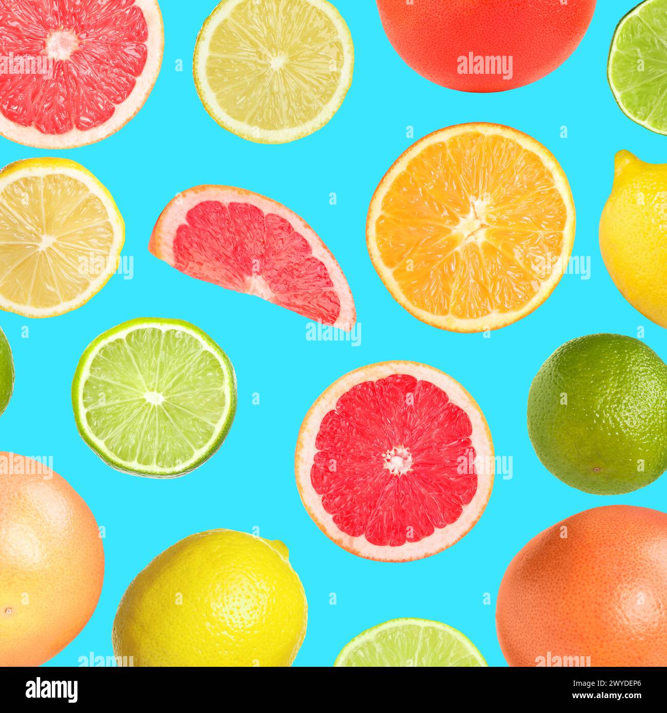 Many different fresh citrus fruits in air on light blue background ...