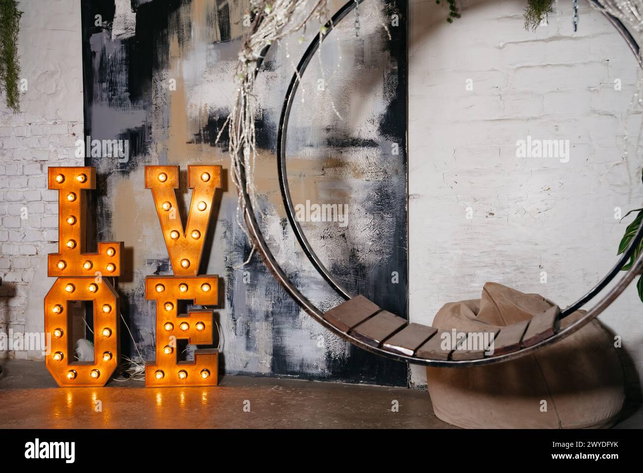 A warm, glowing "LOVE" sign with marquee light bulbs provides a ...