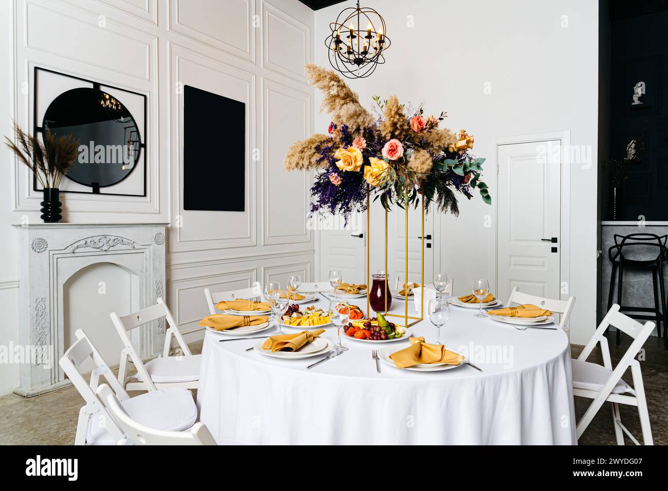A sophisticated dining table arrangement with gold accents and a lavish floral centerpiece in an ...