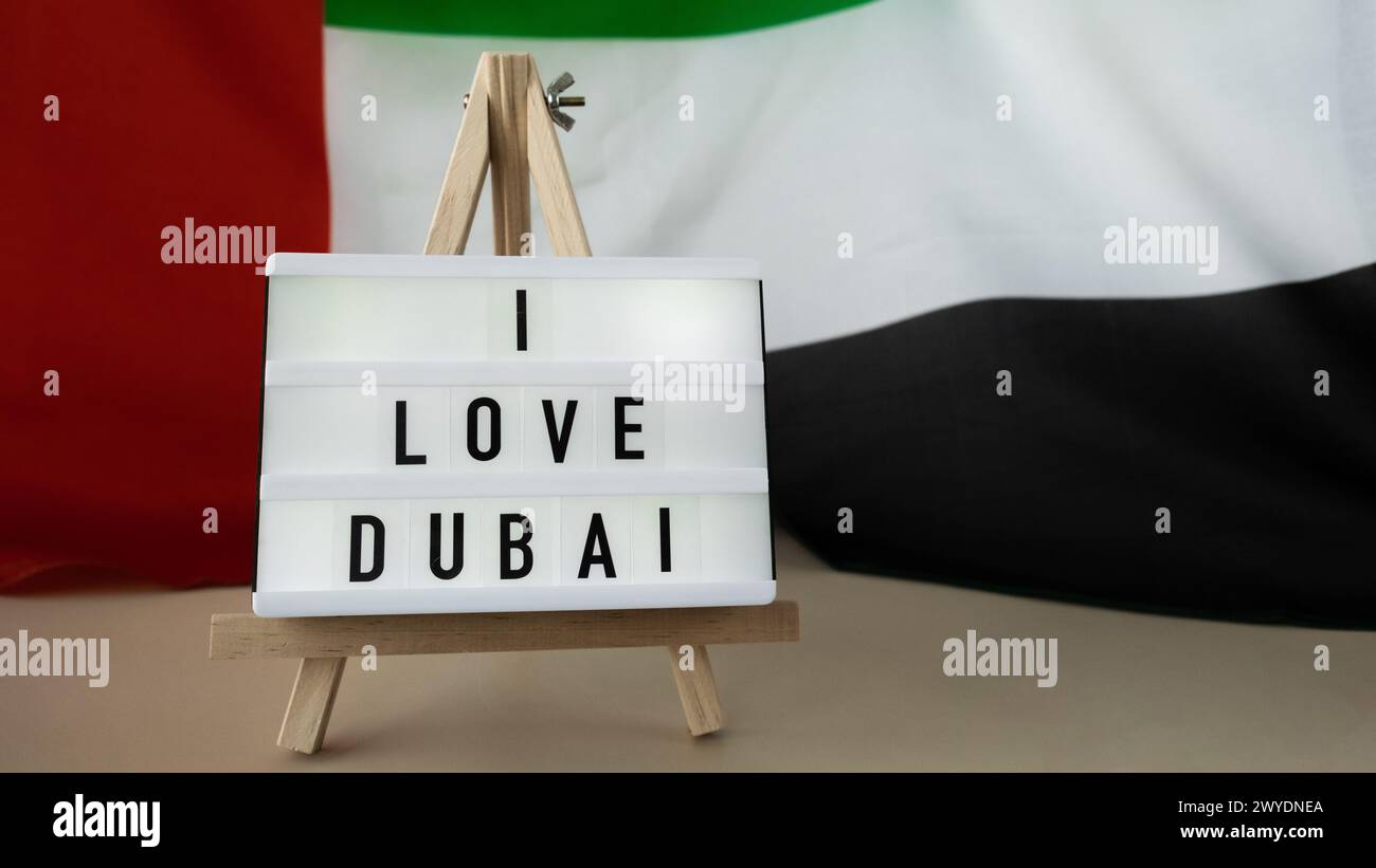 Message text I LOVE DUBAI on background of waving UAE flag made from ...