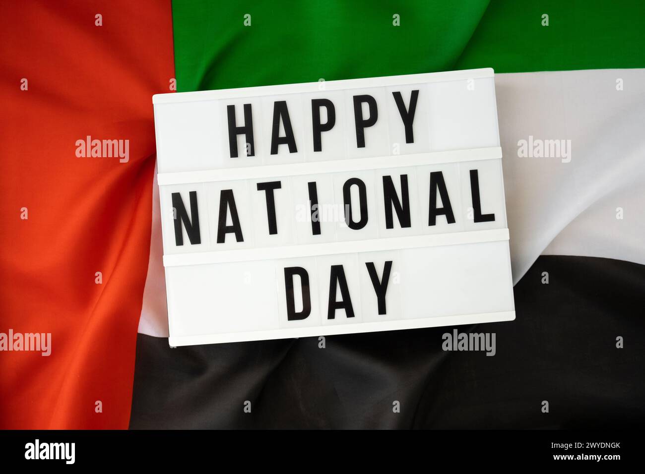 Text HAPPY NATIONAL DAY on background waving flag of UAE. National ...