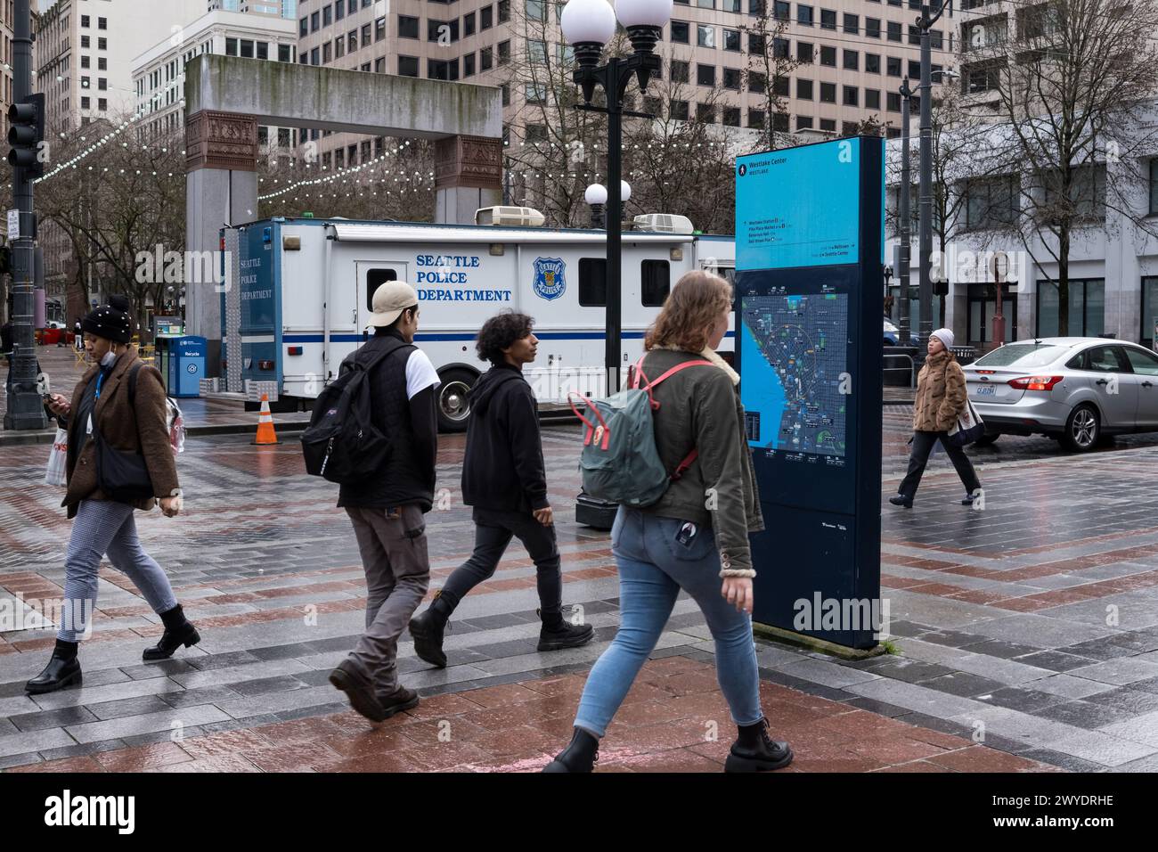 Seattle, USA. 10th Mar, 2024. People passing a tourist map and mobile ...