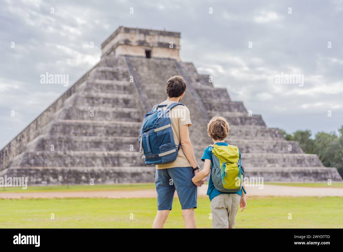 Father and son tourists observing the old pyramid and temple of the ...