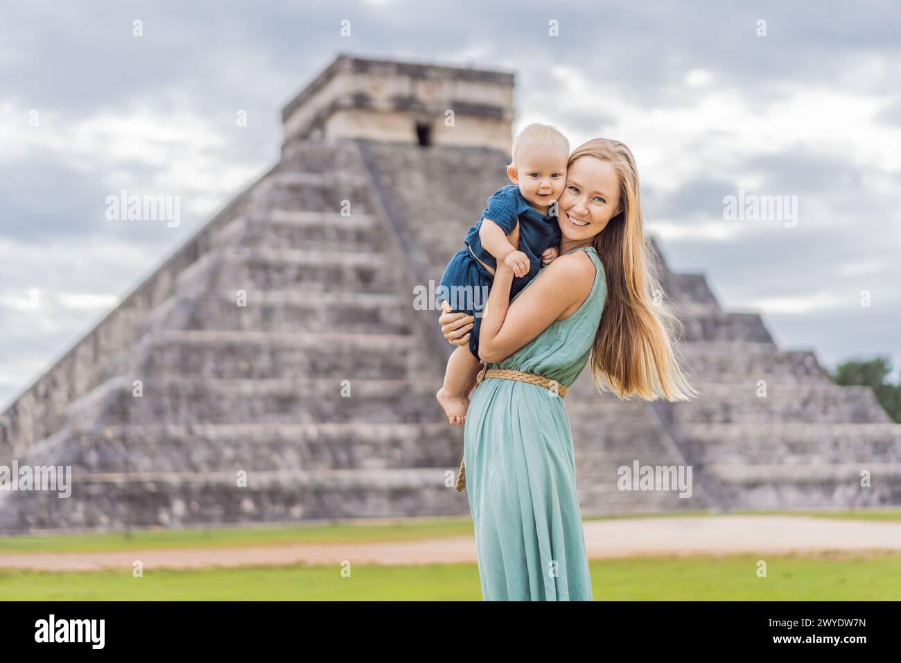 Beautiful tourist woman and her son baby observing the old pyramid and ...