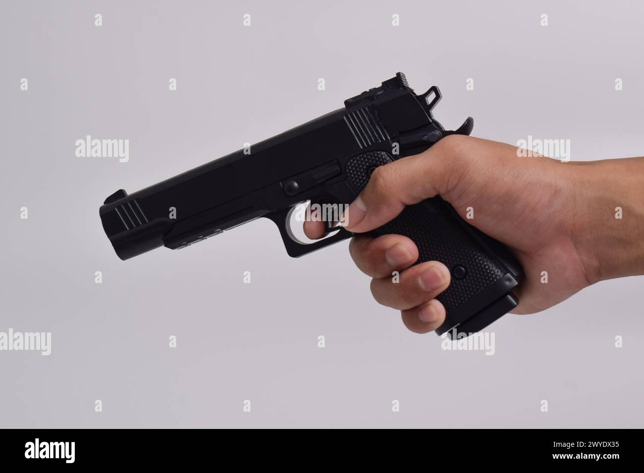 Male hand holding a gun on white background . A Pistol in a man's hand ...