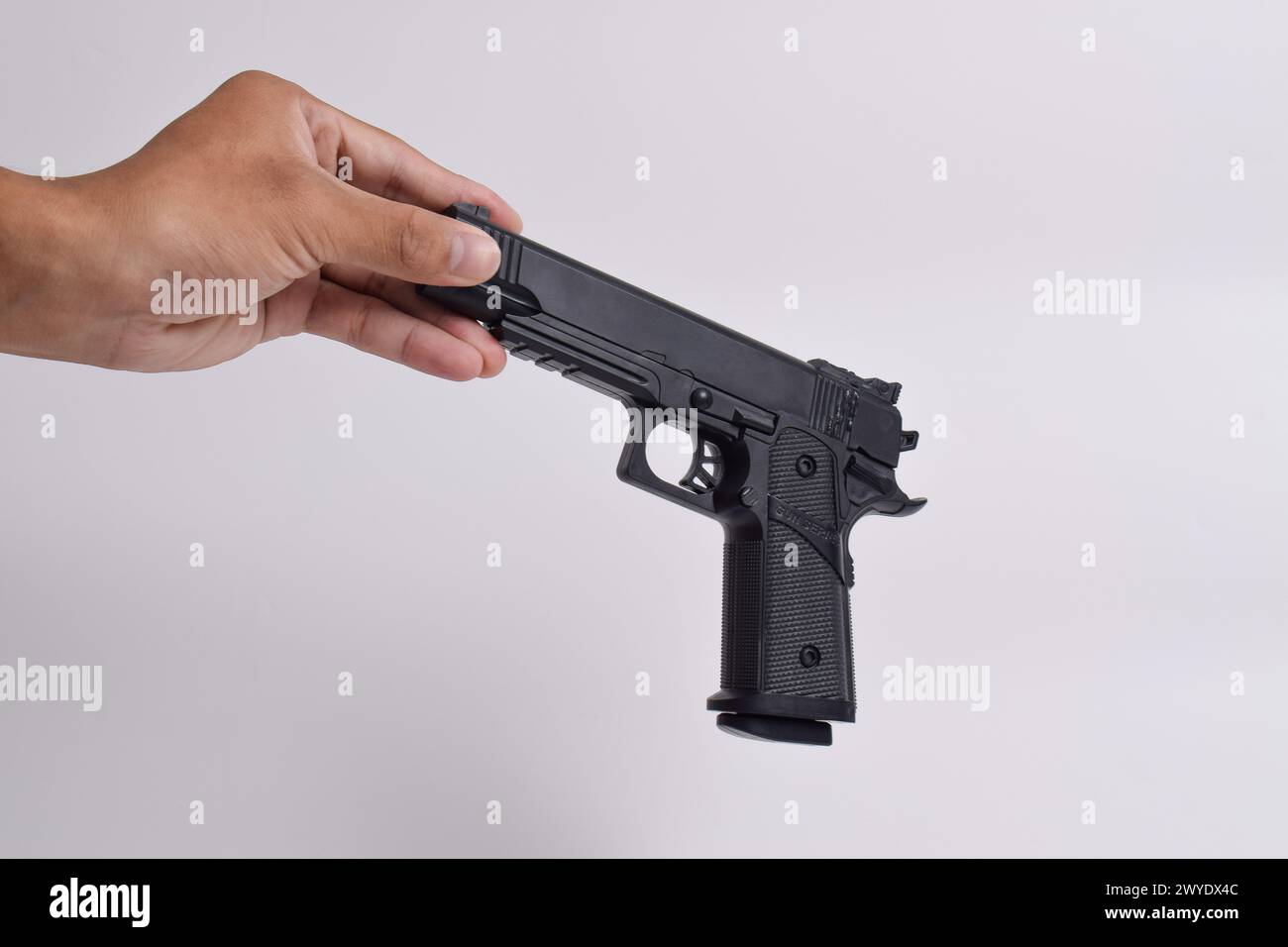 Male hand holding a gun on white background . A Pistol in a man's hand ...
