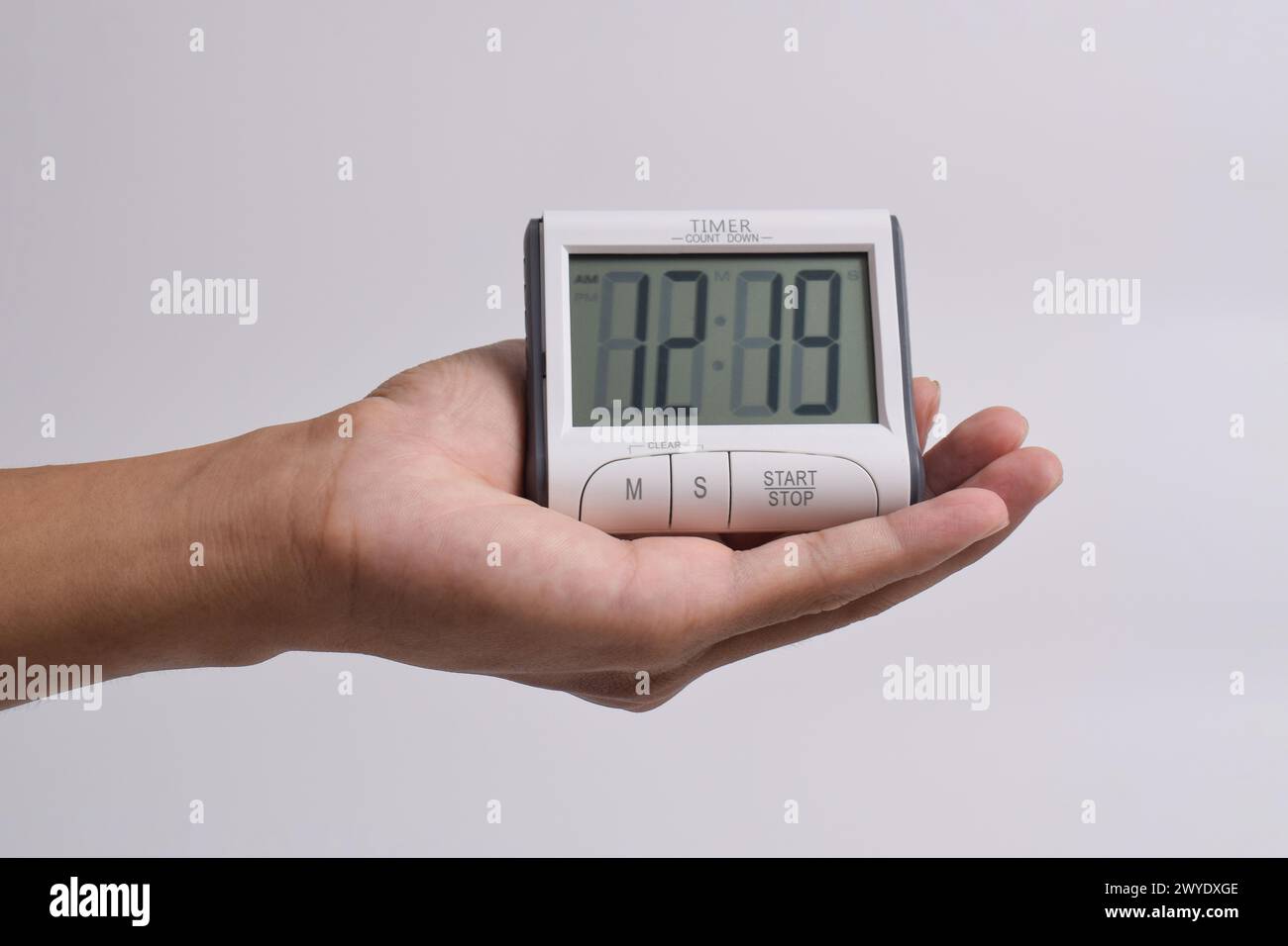 Man's hand holding a Digital kitchen timer on white background. count ...