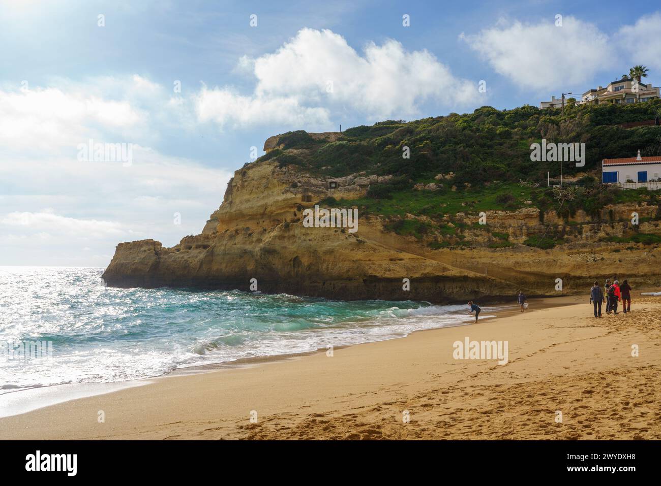 Limestone cliffs border a secluded sandy beach with clear blue waters ...