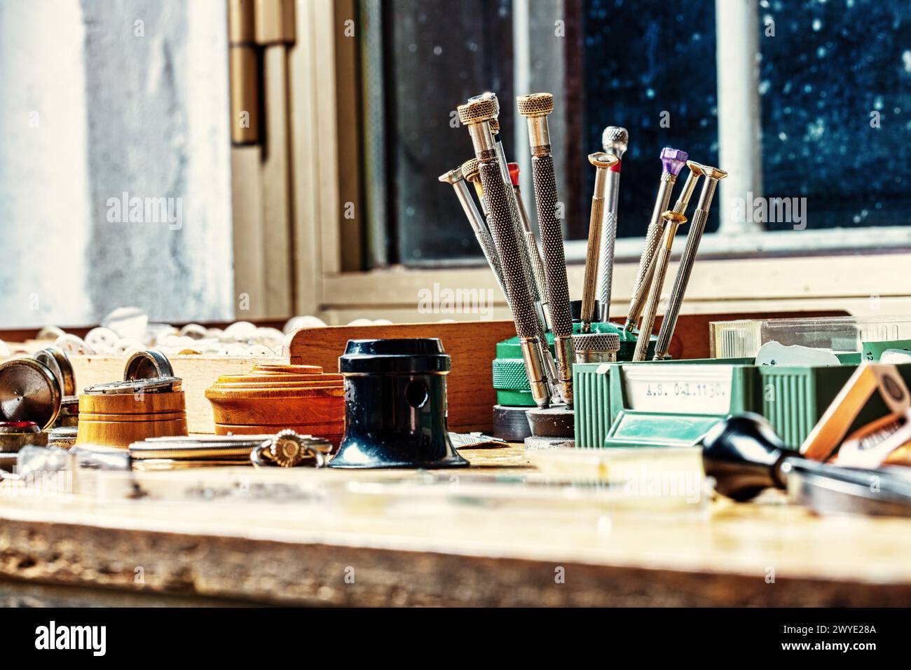 collage of horological tools, wood, and metal occupies the bench, the ...