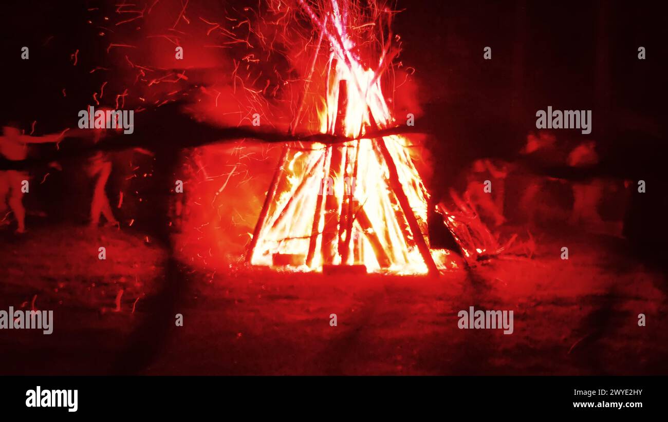 Huge fire at night and young people around. Pagan festival of Walpurgis ...
