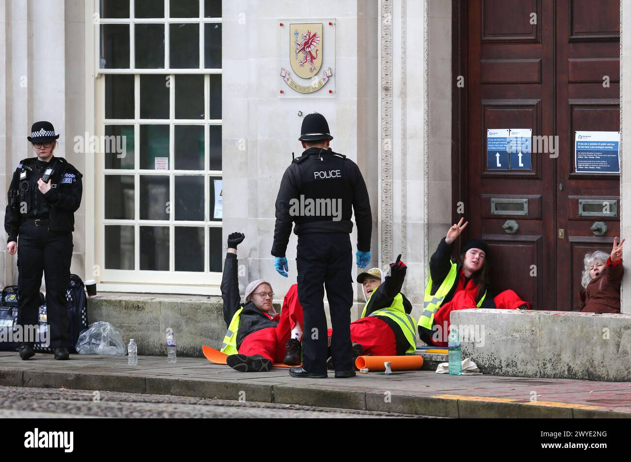 A police officer interacts with protesters blocking the entrance to ...